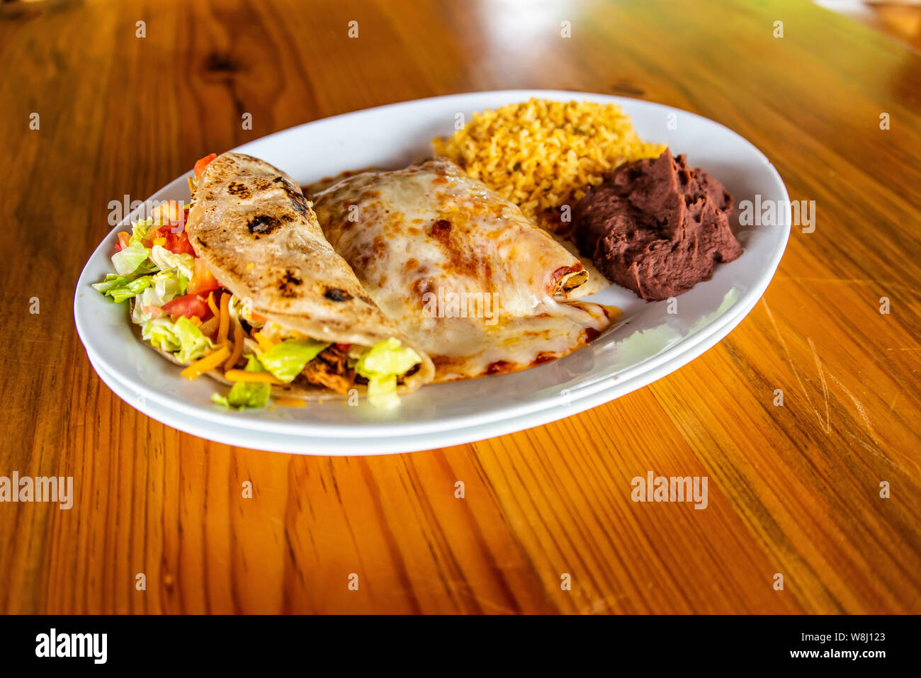 Chicken Enchilada plate with rice, beans and chicken taco Stock Photo ...