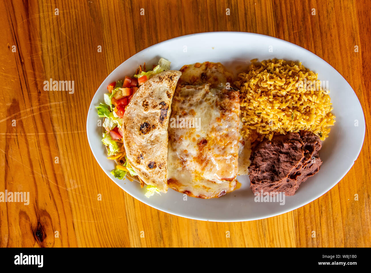 Chicken Enchilada plate with rice, beans and chicken taco Stock Photo ...