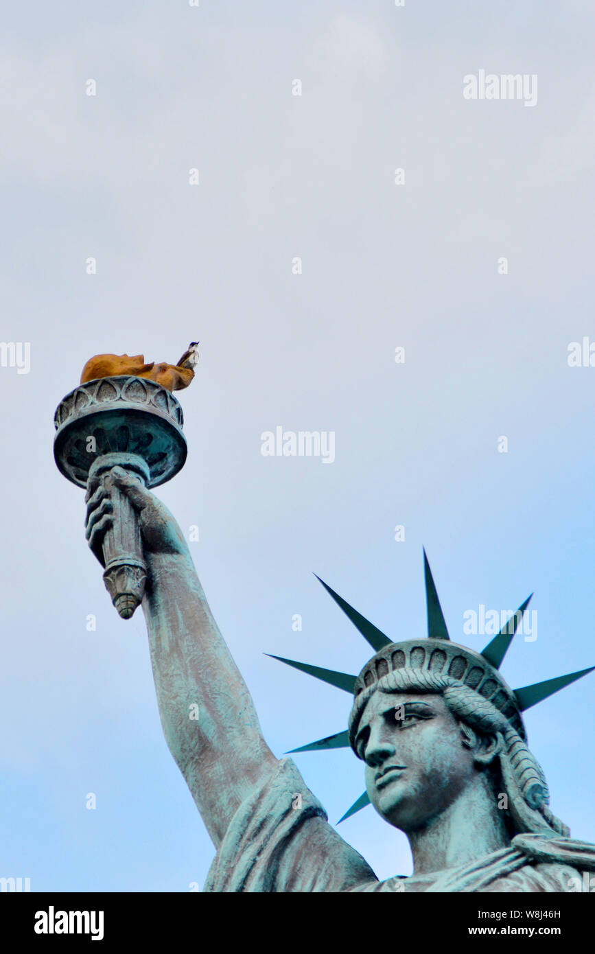 A bird stands atop a downsized replica of the Statue of Liberty in the ...