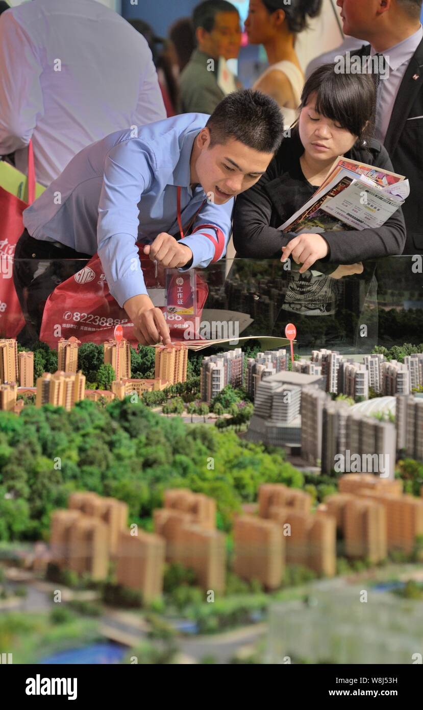 --FILE--A Chinese employee introduces models of residential apartment ...