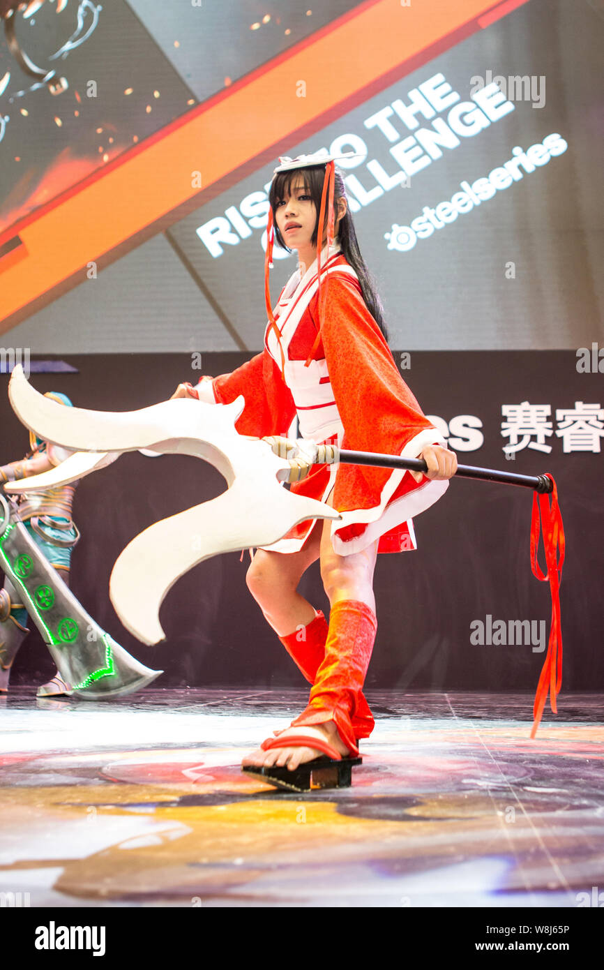 A showgirl dressed in a cosplay costume poses at the stand of computer ...