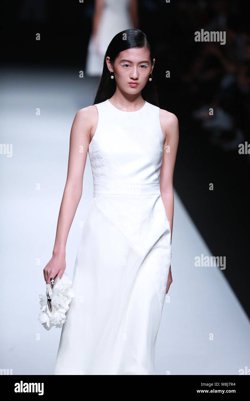 A model displays a new creation at the fashion show of Chinese fashion ...