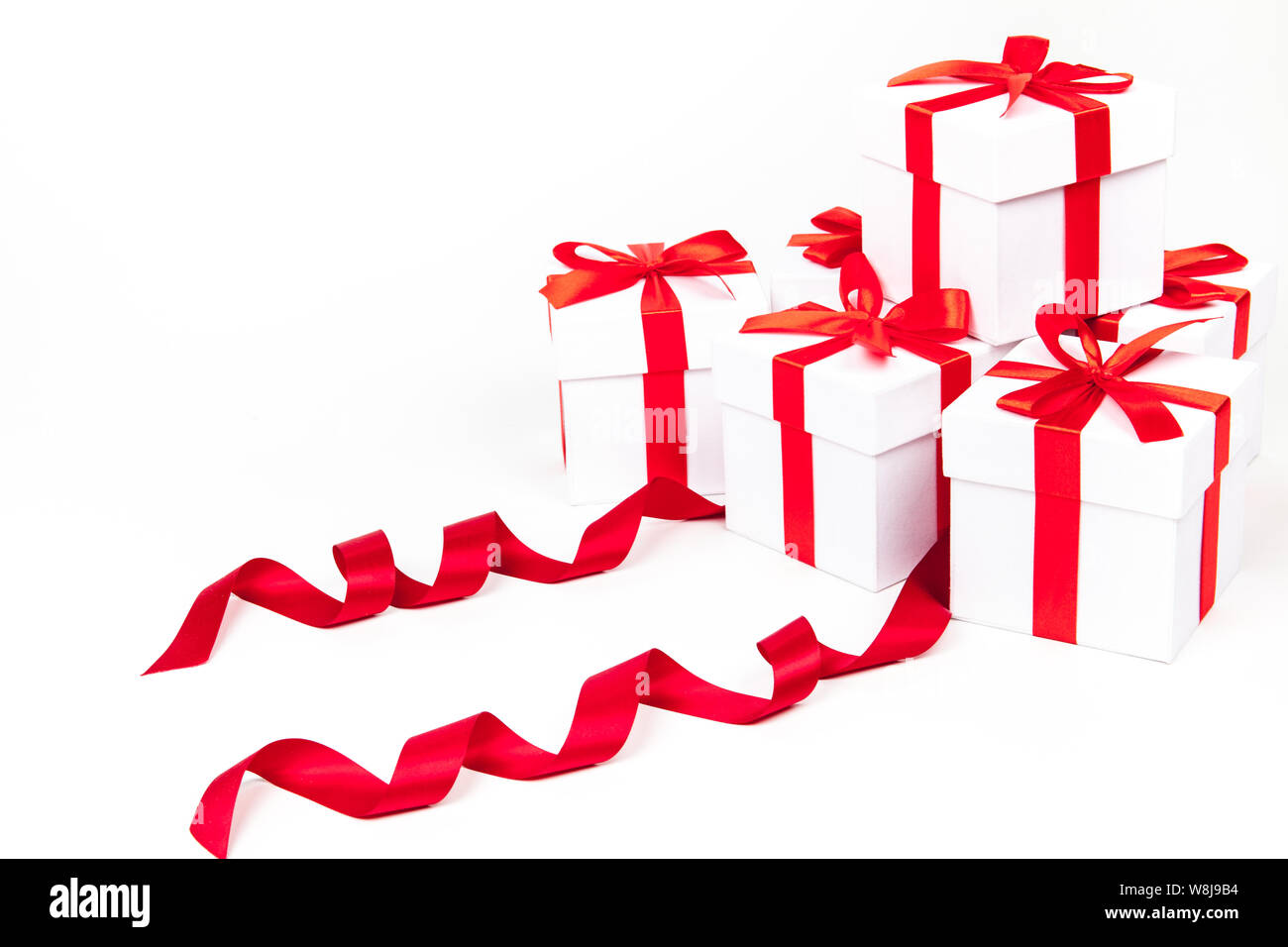 White boxes with a red satin ribbon bow Isolated on white background ...