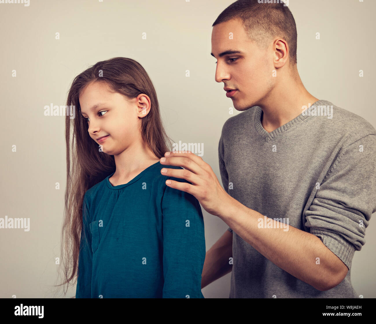 Young father speaking with his daughter holding her shoulder the hand ...