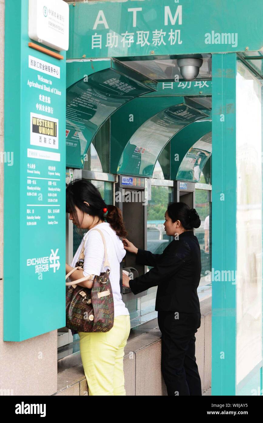 --FILE--Local residents withdraw money from ATMs at a branch of ...