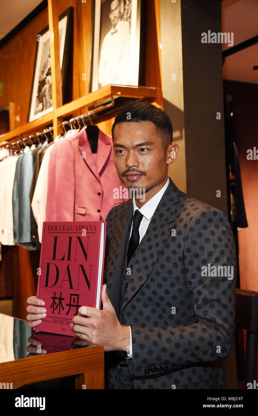 Chinese badminton star Lin Dan poses with his photo album at a signing ...