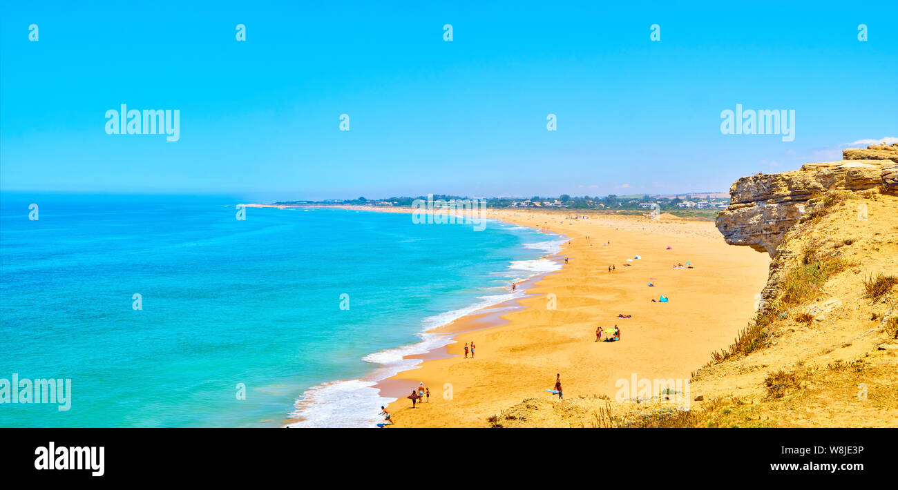 People enjoying a sunbathing in The Faro de Trafalgar Beach, a broad ...