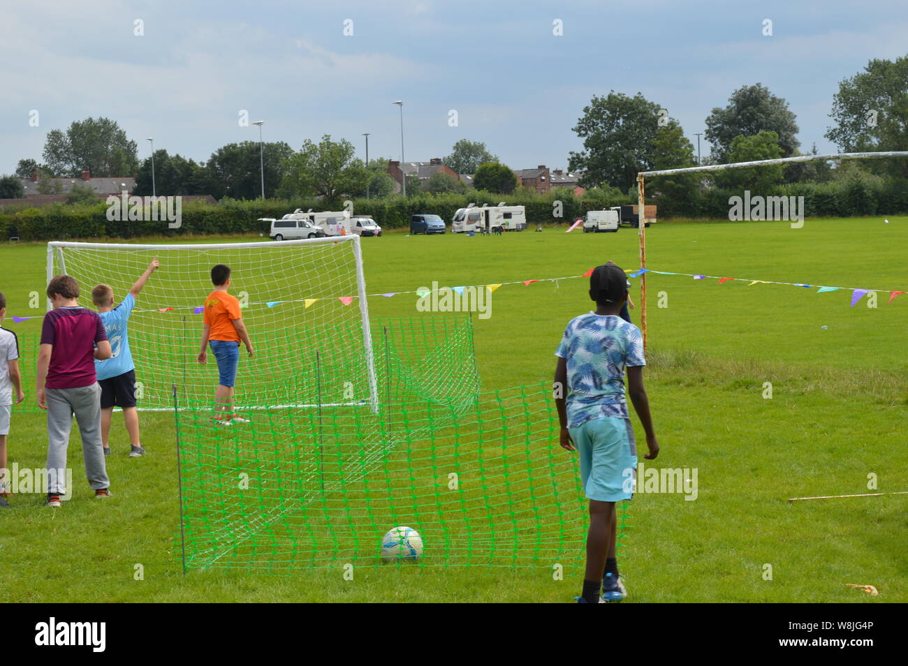 Parent watching their Kids playing football Stock Photo - Alamy