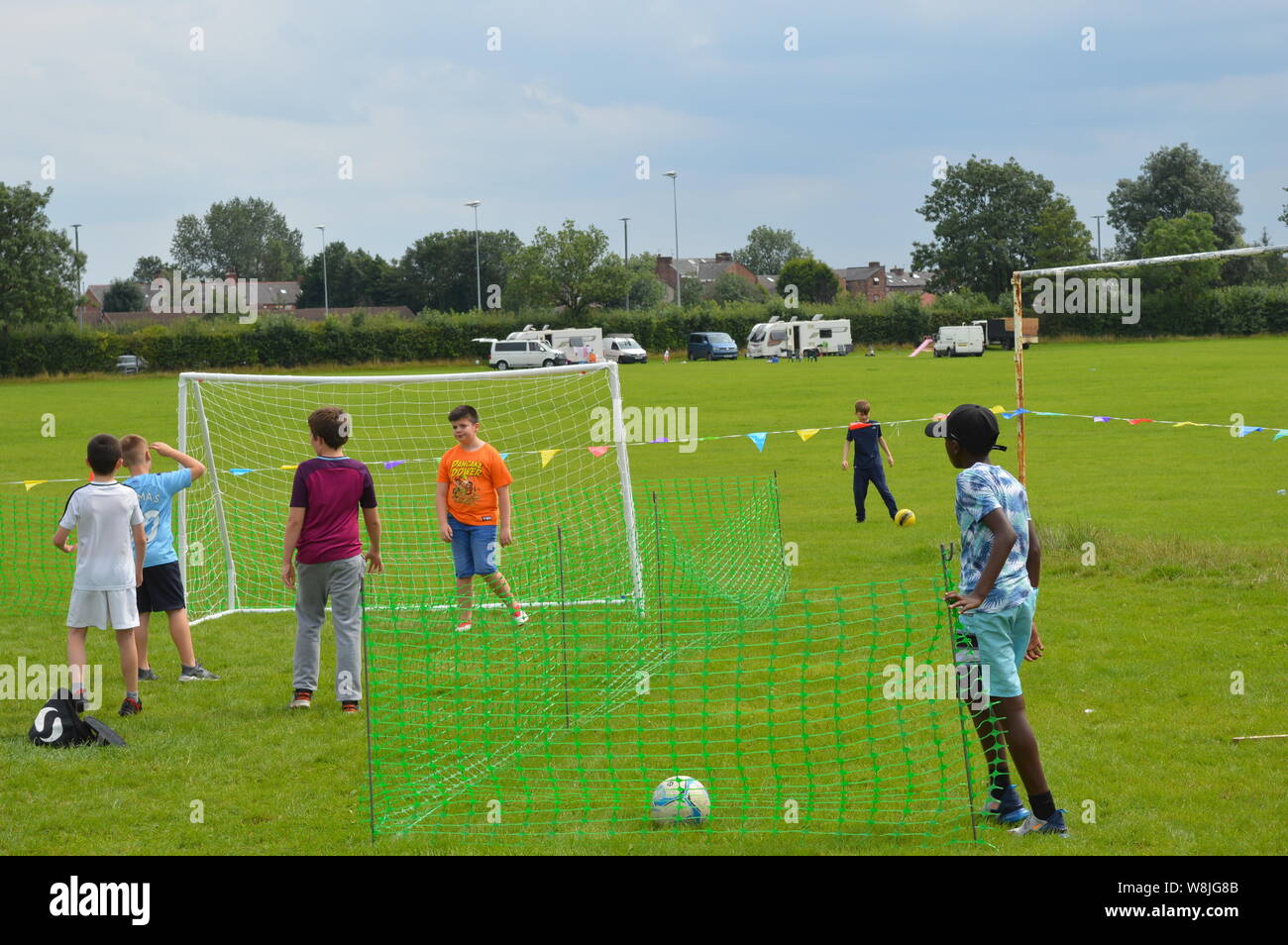 Parent watching their Kids playing football Stock Photo - Alamy