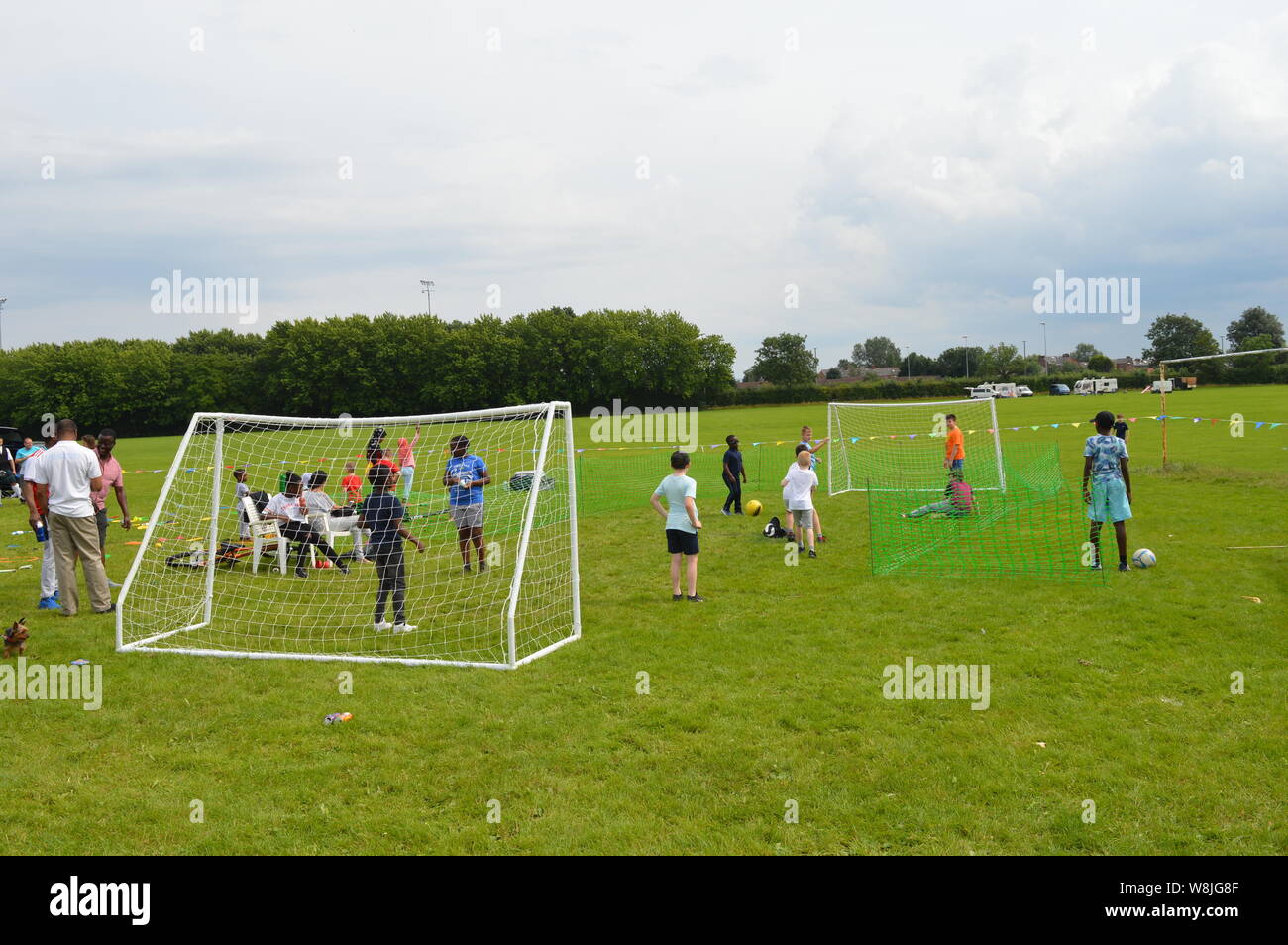 Parent watching their Kids playing football Stock Photo - Alamy