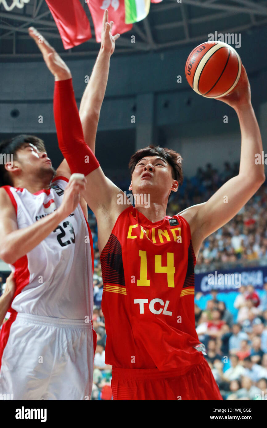 Wang Zhelin of China, right, drives to the basket against Singapore in ...