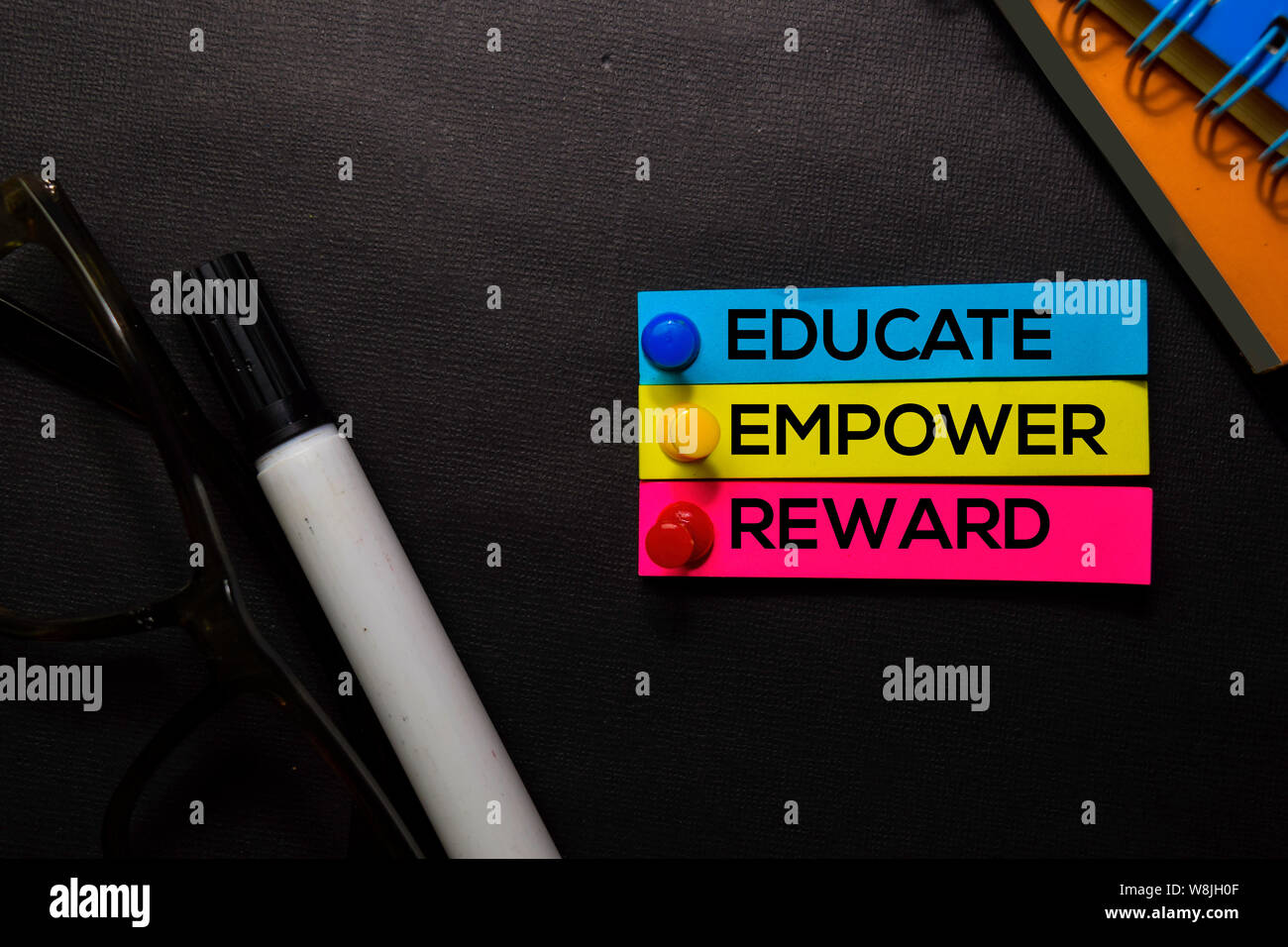 Educate, Empower, Reward text on sticky notes isolated on Black desk ...