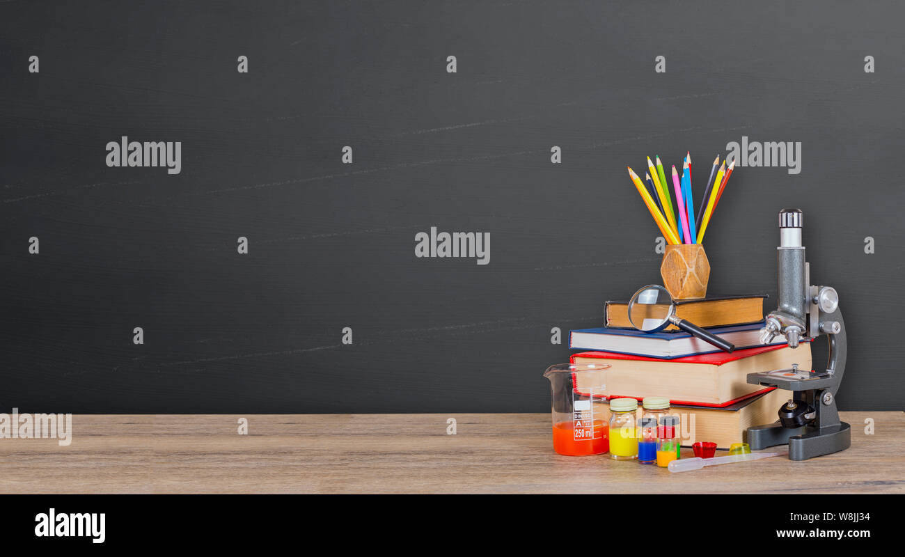 microscope book and test tubes in front of chalkboard Stock Photo - Alamy
