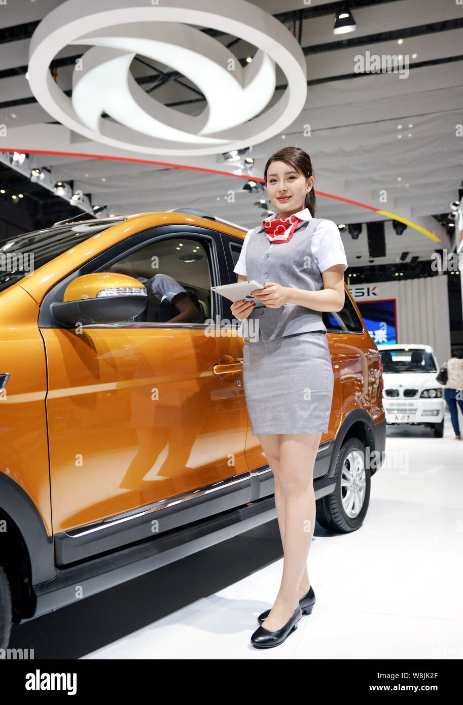 A hostess poses at the stand of Dongfeng Motor during the 16th Shanghai ...