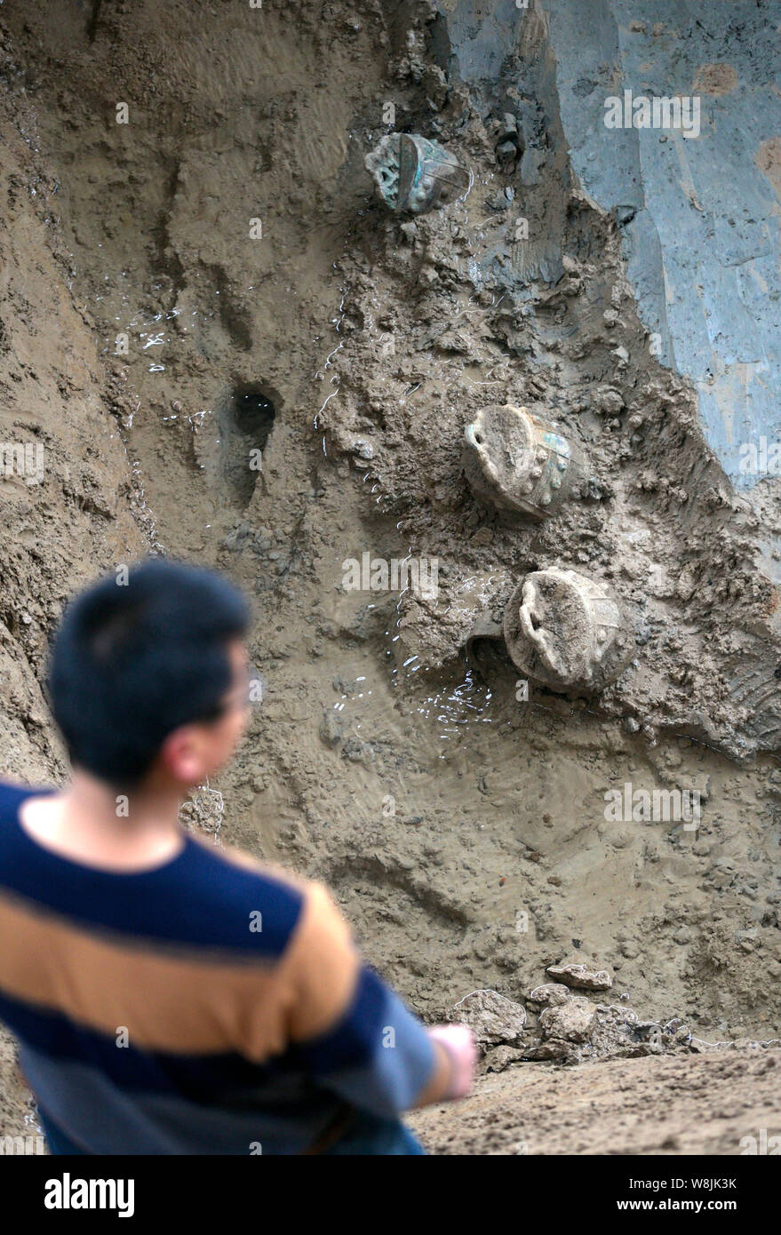 A Chinese archaeologist surveys bronze bells at the site of a 2,500 ...