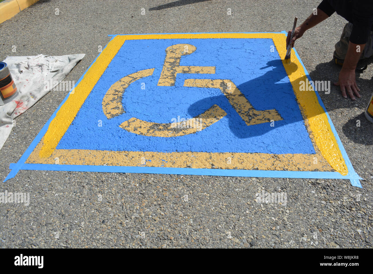 Painter repainting handicap parking on street pavement Stock Photo - Alamy