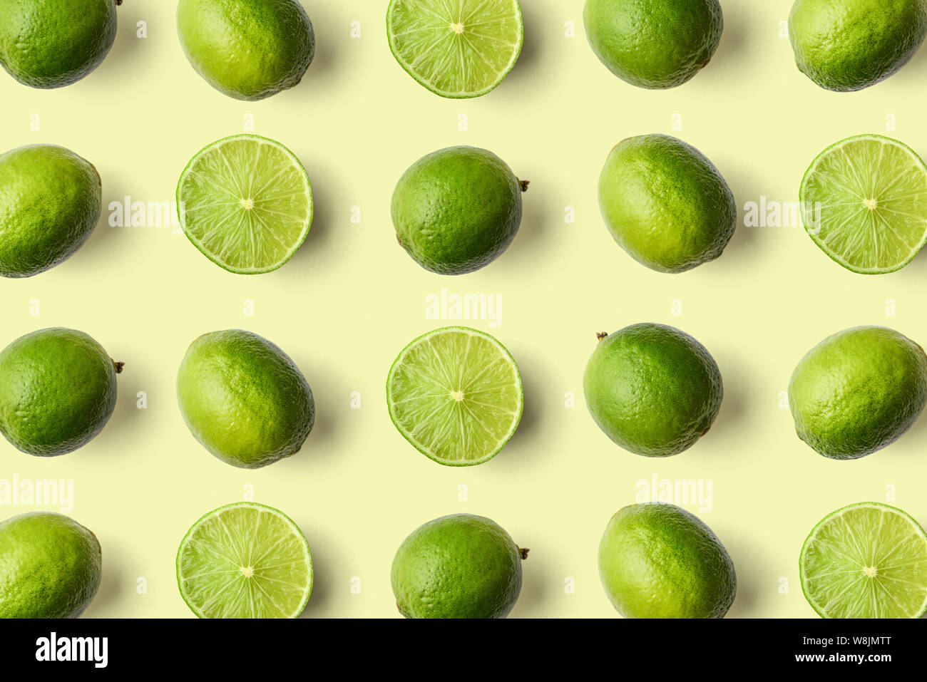 Colorful fruit pattern of limes on yellow background, top view Stock ...