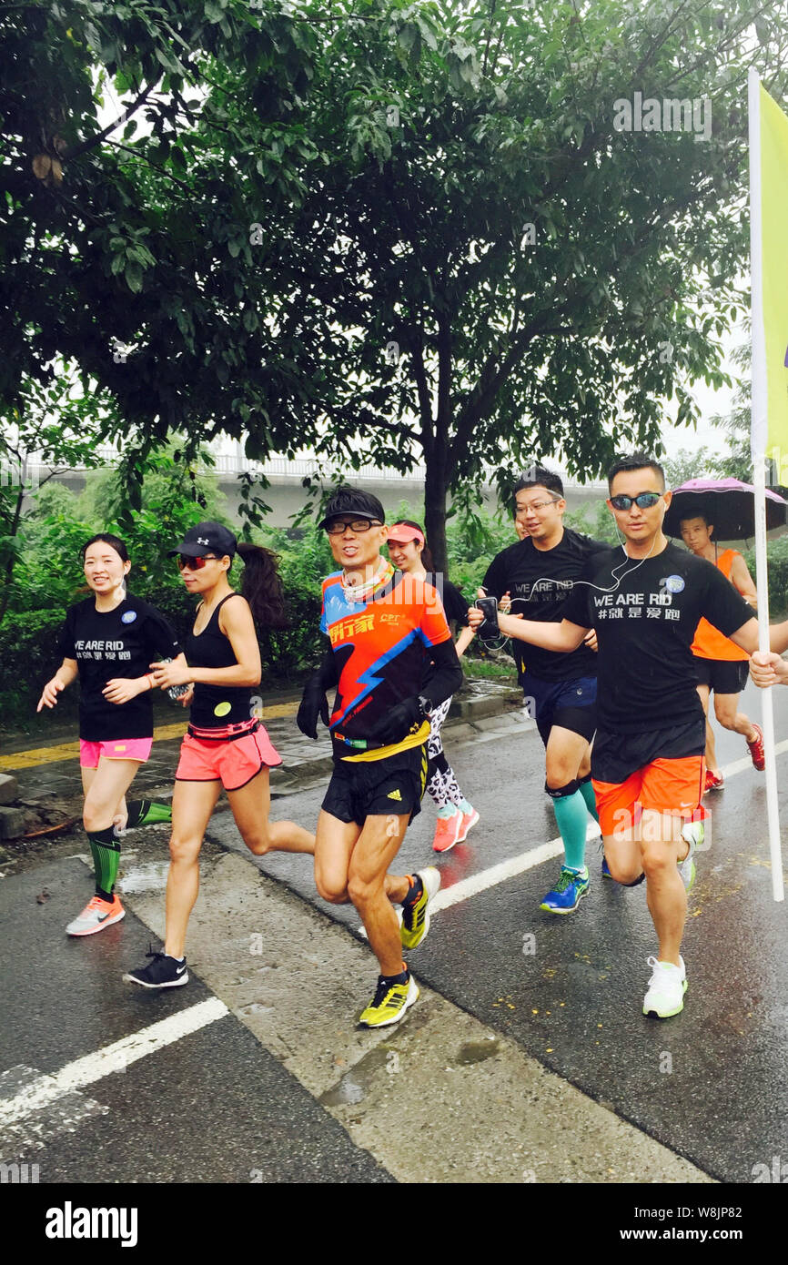 47-year-old Chinese street cleaner Chen Xuejun, center, jogs with other ...