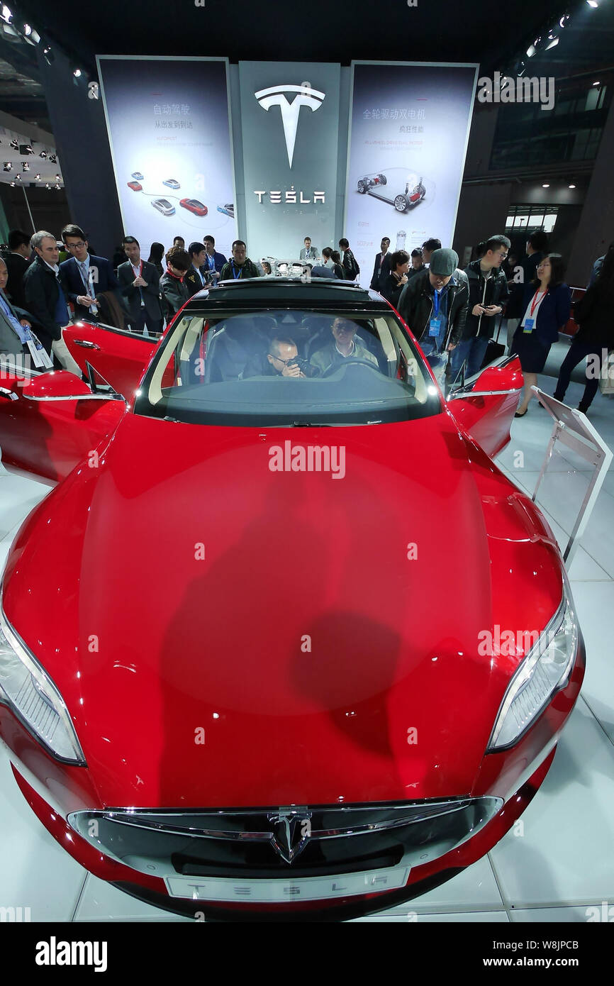 --FILE--Visitors look at or try out a Tesla model S electric car during ...