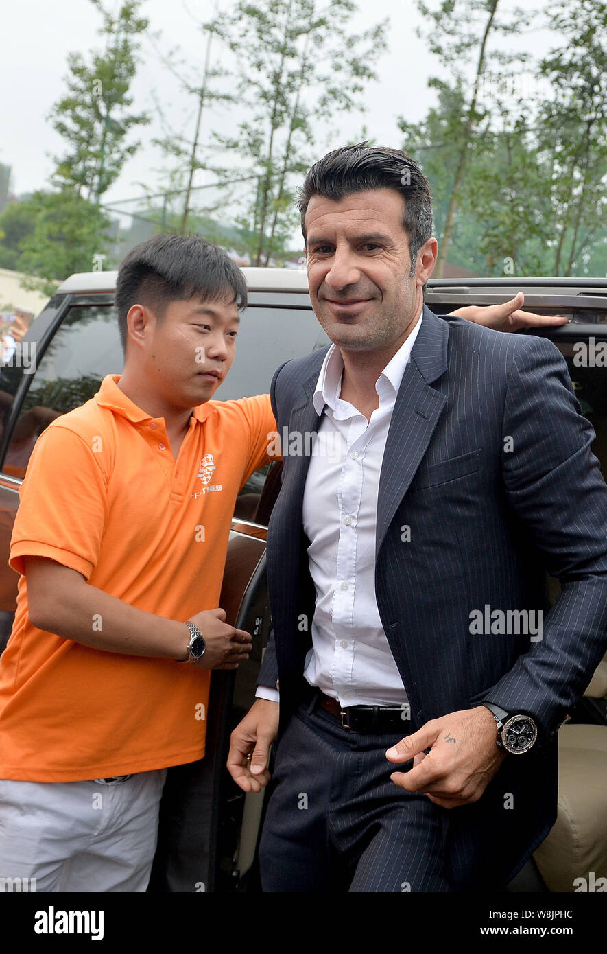 Portuguese football star Luis Figo, right, smiles as he arrives at the ...