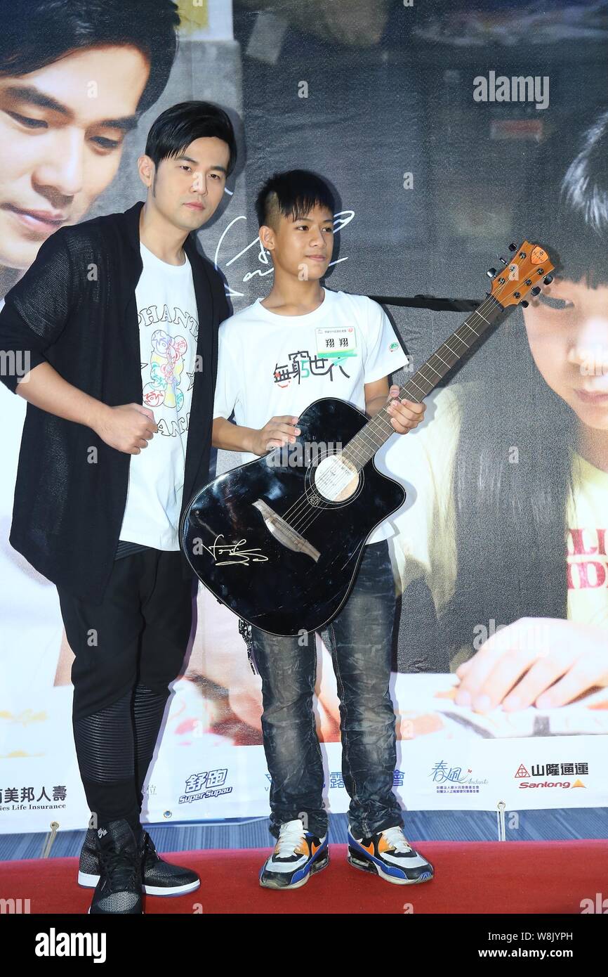Taiwanese singer and actor Jay Chou, left, poses with a young boy at a ...