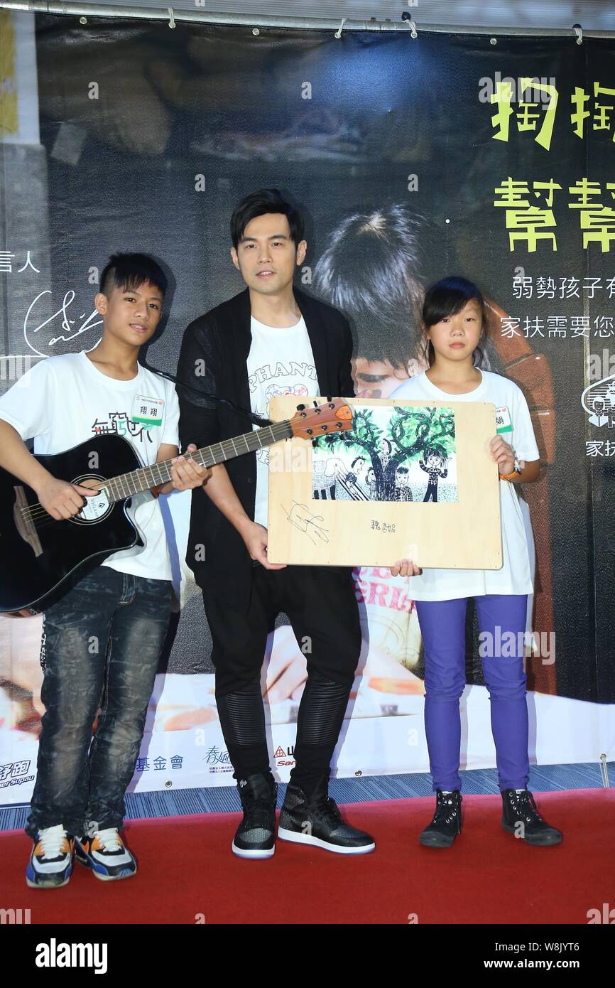 Taiwanese singer and actor Jay Chou, center, poses with young kids at a ...
