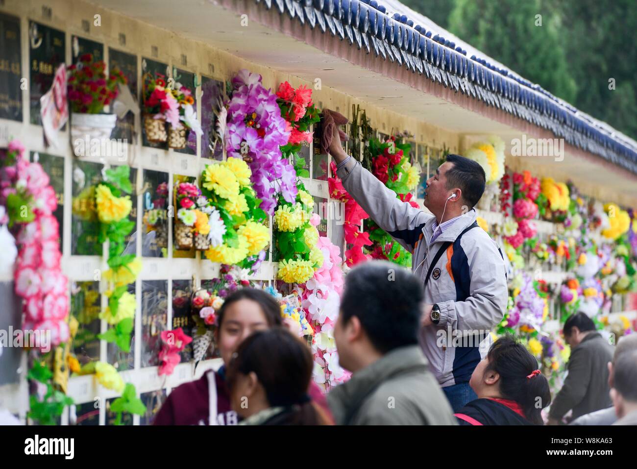 People visit the tombs of their deceased relatives at a cemetery during ...