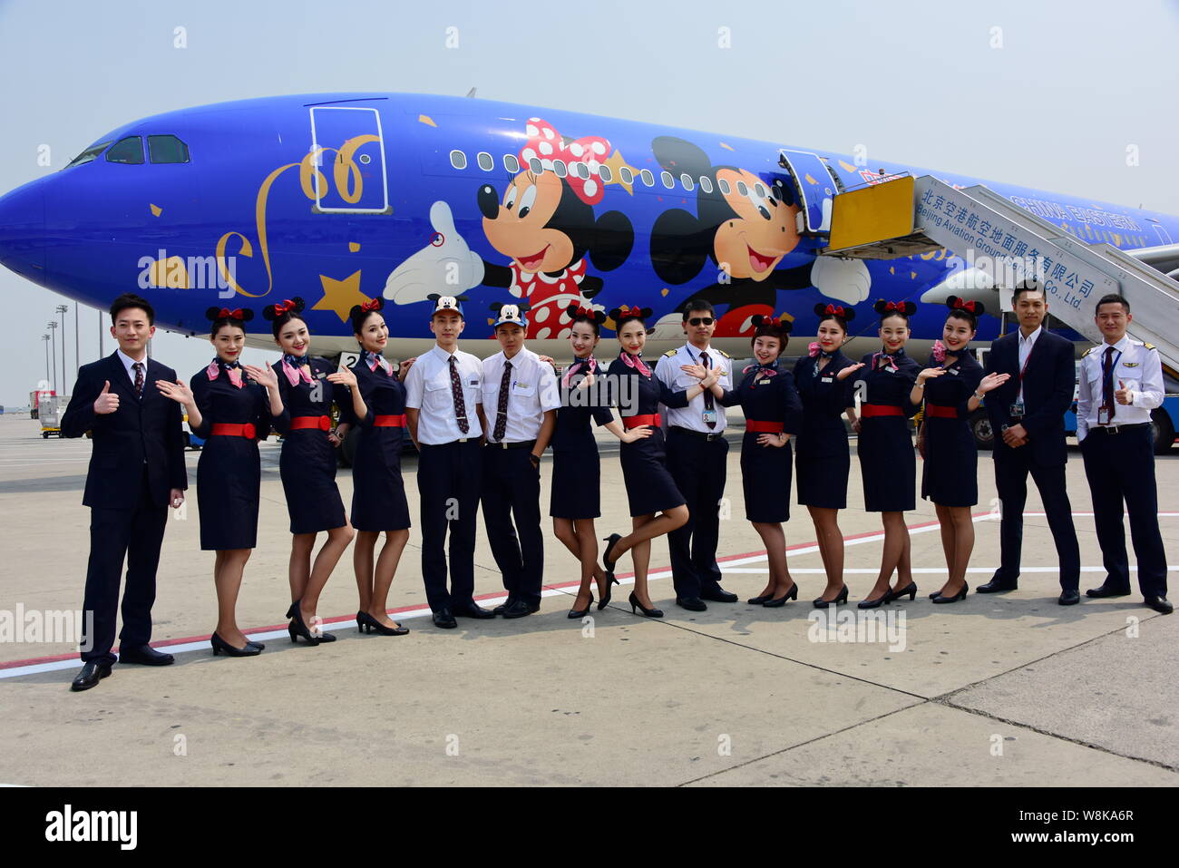 Chinese air hosts and hostesses wearing Mickey and Minnie Mouse ...