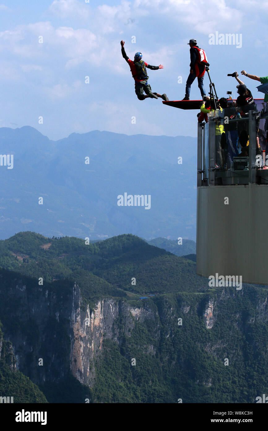 A contestant jumps off the glass cantilever bridge on the cliff during ...