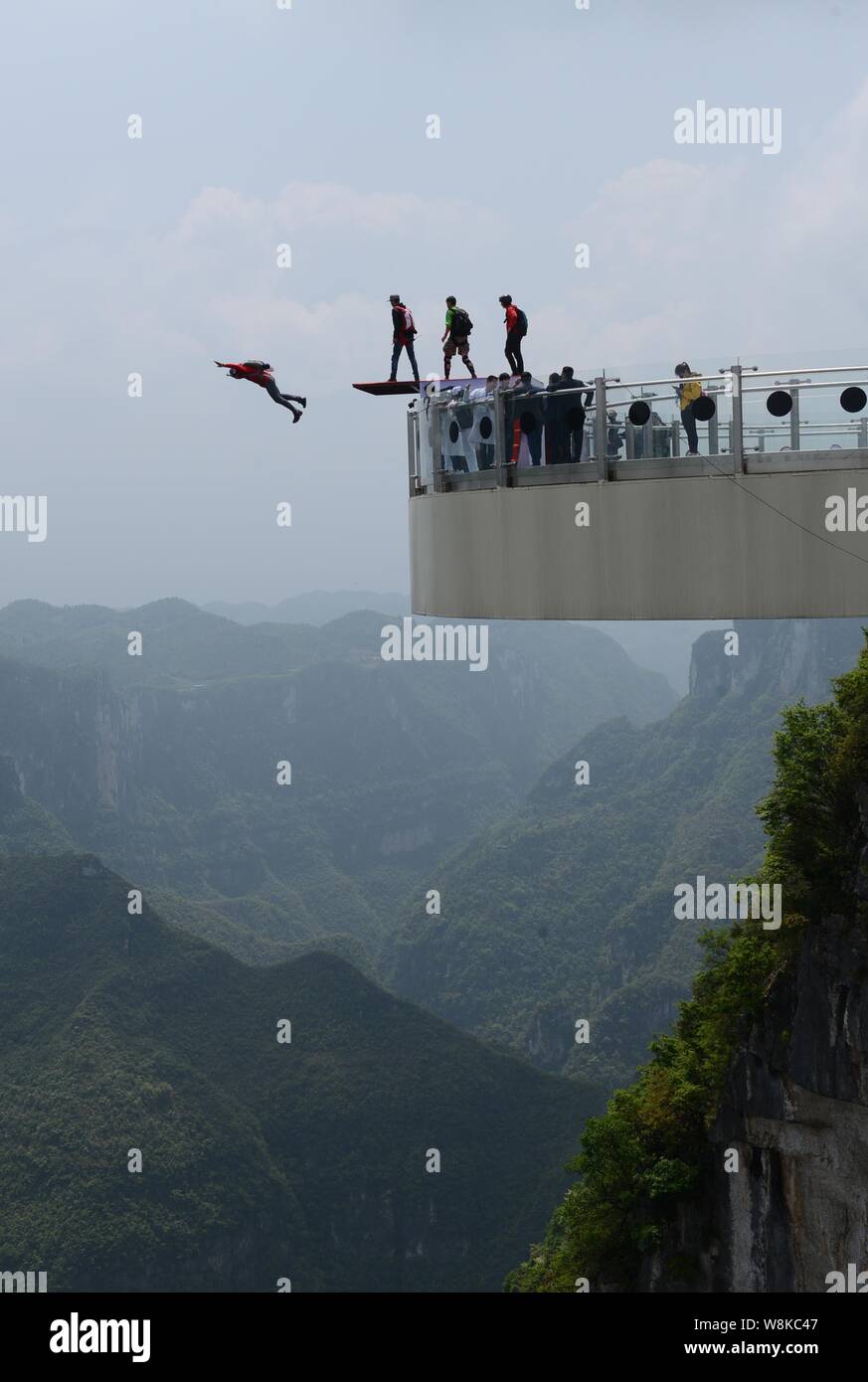 A contestant jumps off the glass cantilever bridge on the cliff during ...