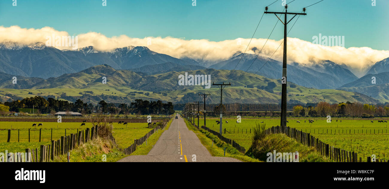 Rural road from the Eastern hills to the cloud covered Tararua ranges ...