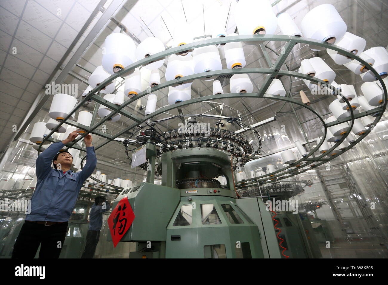 --FILE--A Chinese worker handles production of yarn at a textile ...