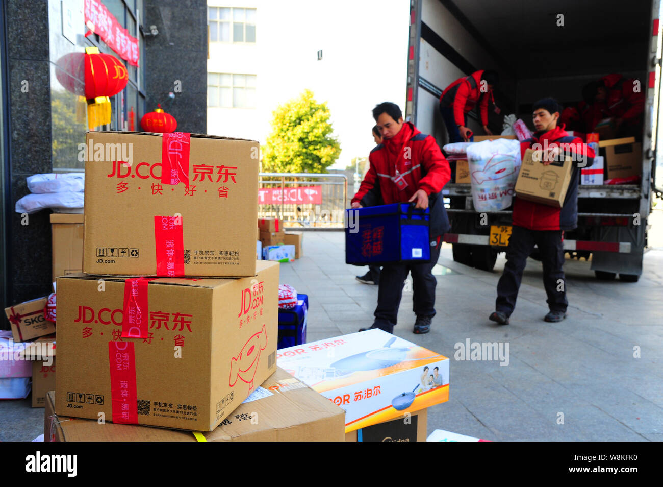 --FILE--Chinese couriers unload parcels from a van at a distribution ...