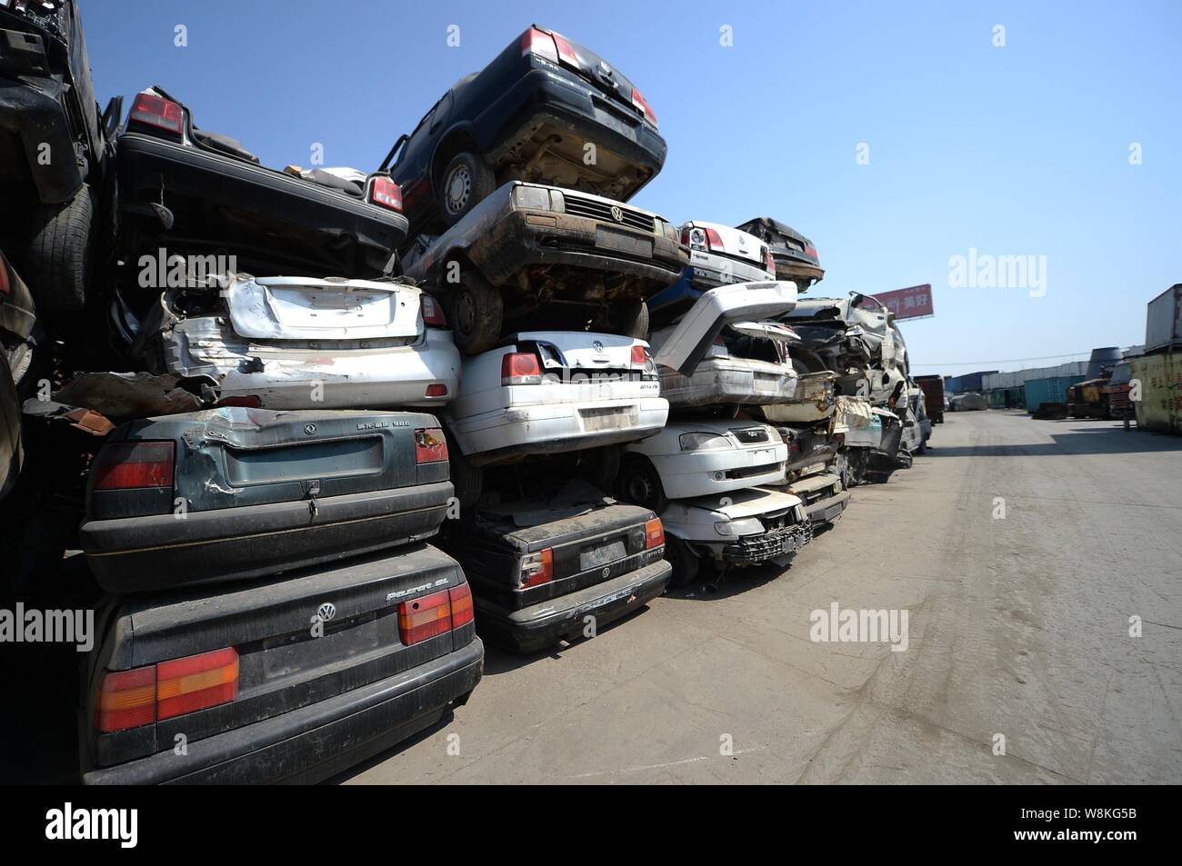 Scrapped vehicles are piled up in a car recycling and dismantling ...