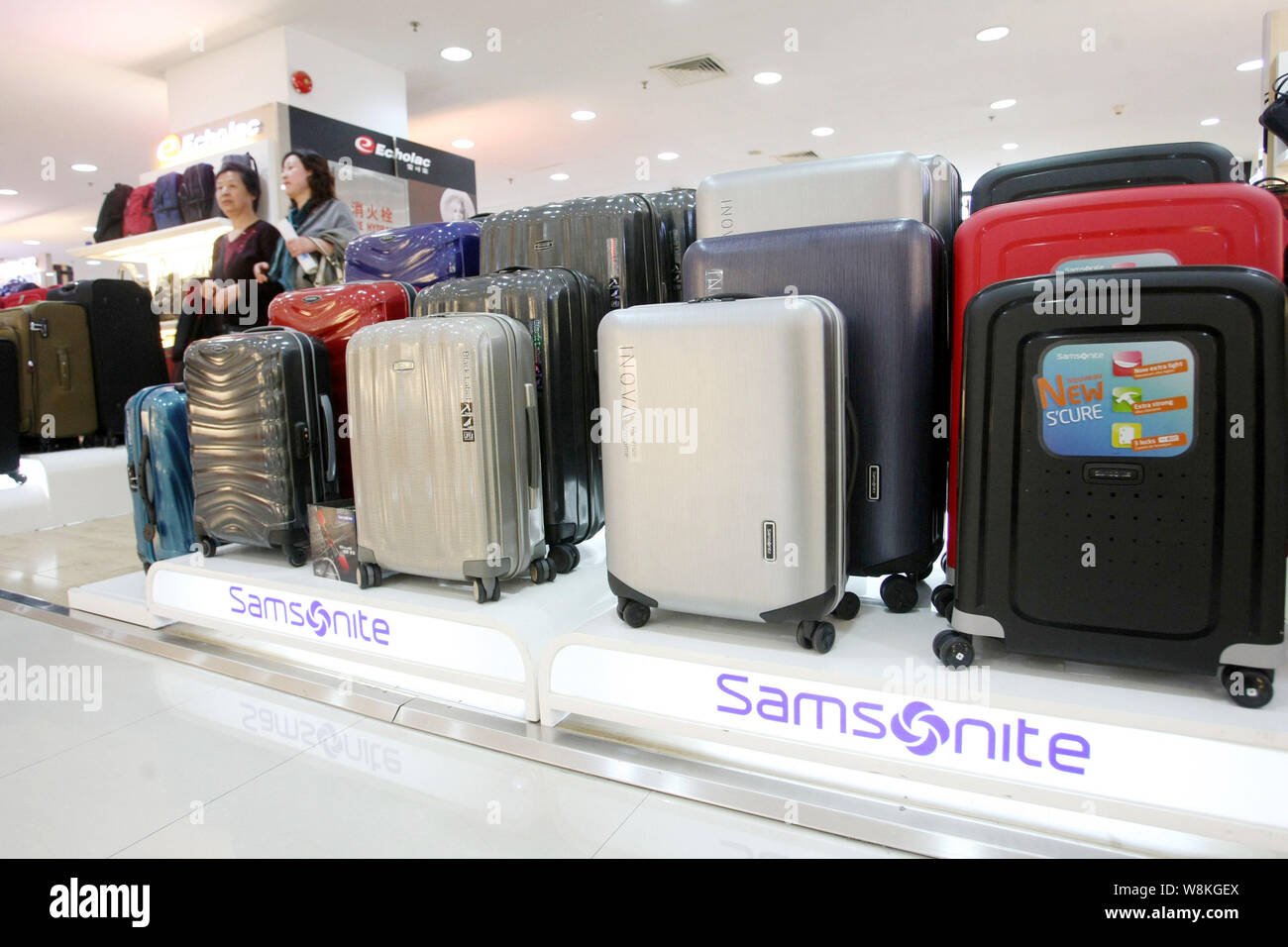--FILE--Chinese shoppers walk past luggages of Samsonite for sale at a ...