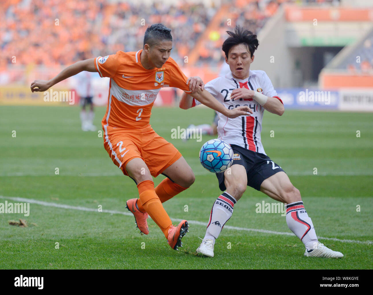 Zhao Mingjian of China's Shandong Luneng, left, challenges Ko Kwang-min ...