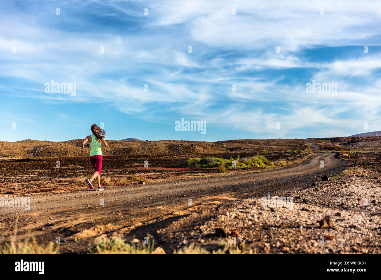 Trail runner female athlete running in dramatic volcano landscape on ...