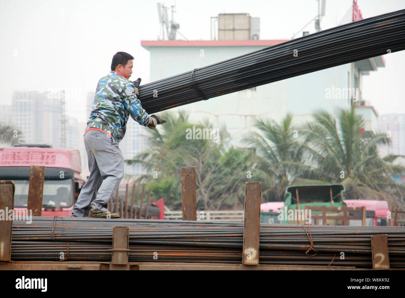 --FILE--A Chinese worker directs a crane to lift a bundle of ...