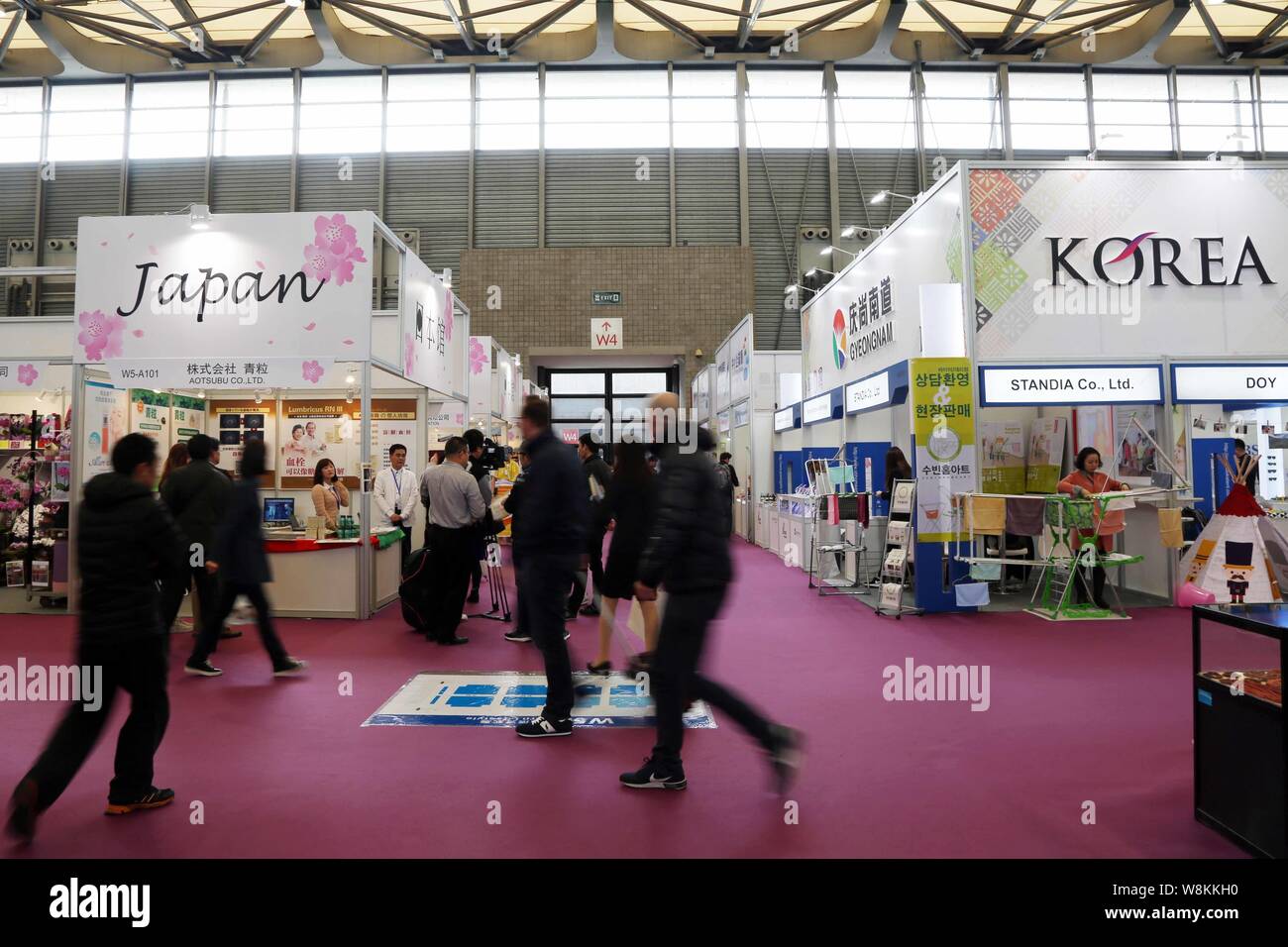 Visitors walk past booths in the exhibition area for Japan and South ...