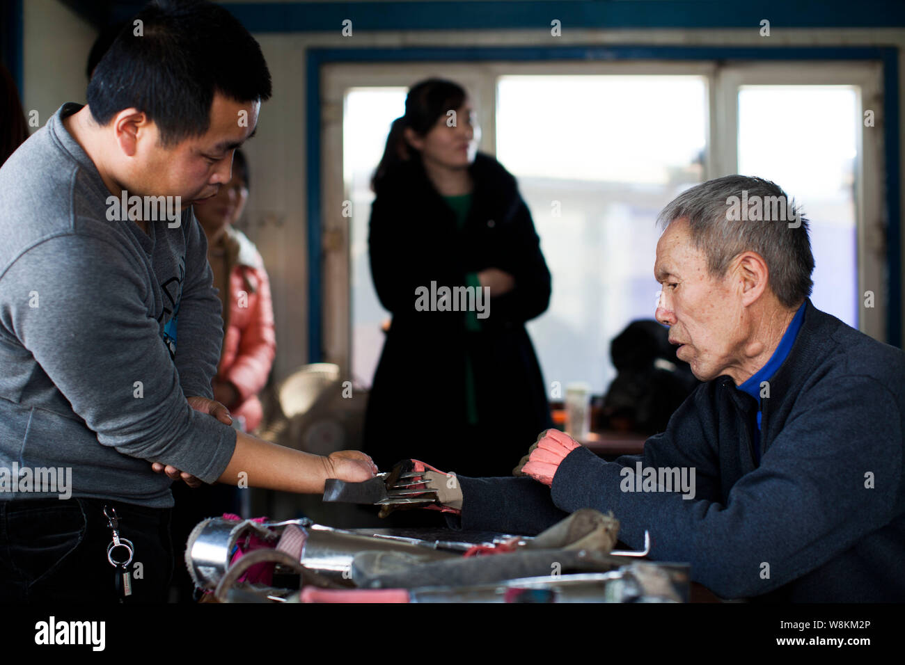 63-year-old armless farmer Sun Jifa, right, who is equipped with his ...