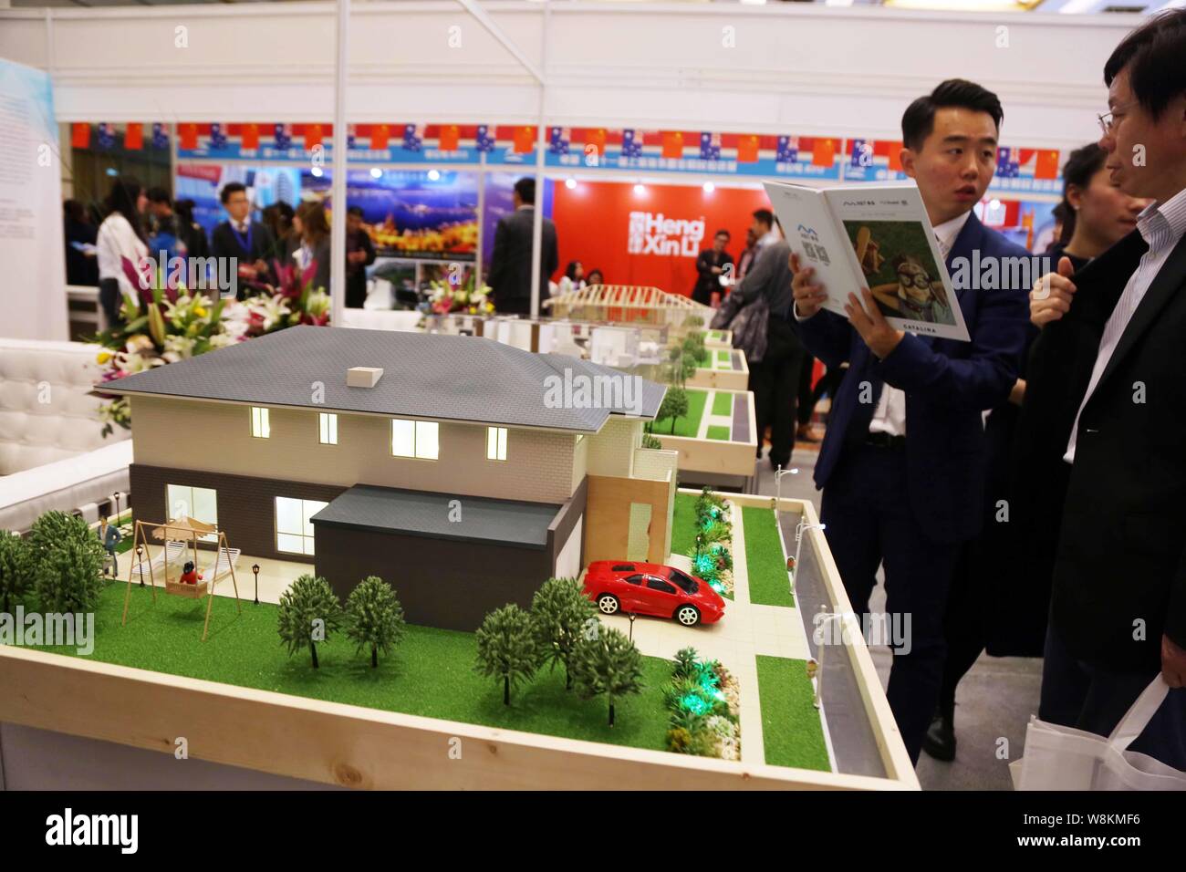 A Chinese employee introduces models of residential buildings to a ...