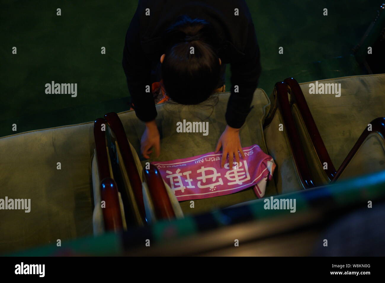 A staff member puts a banner with the name of Chinese girl group SNH48 ...