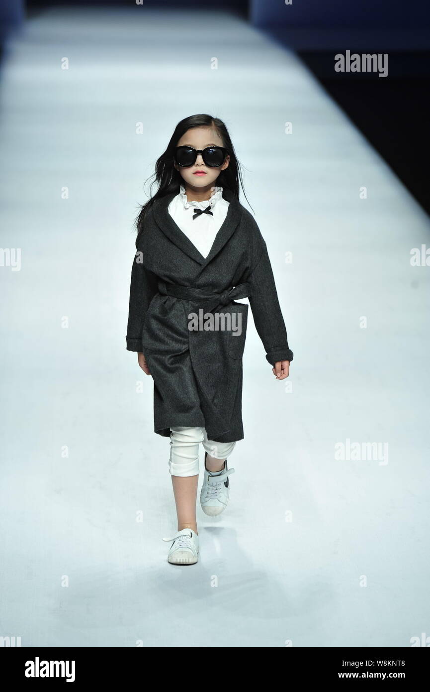 A child model displays a new creation at the fashion show of Tingzu ...