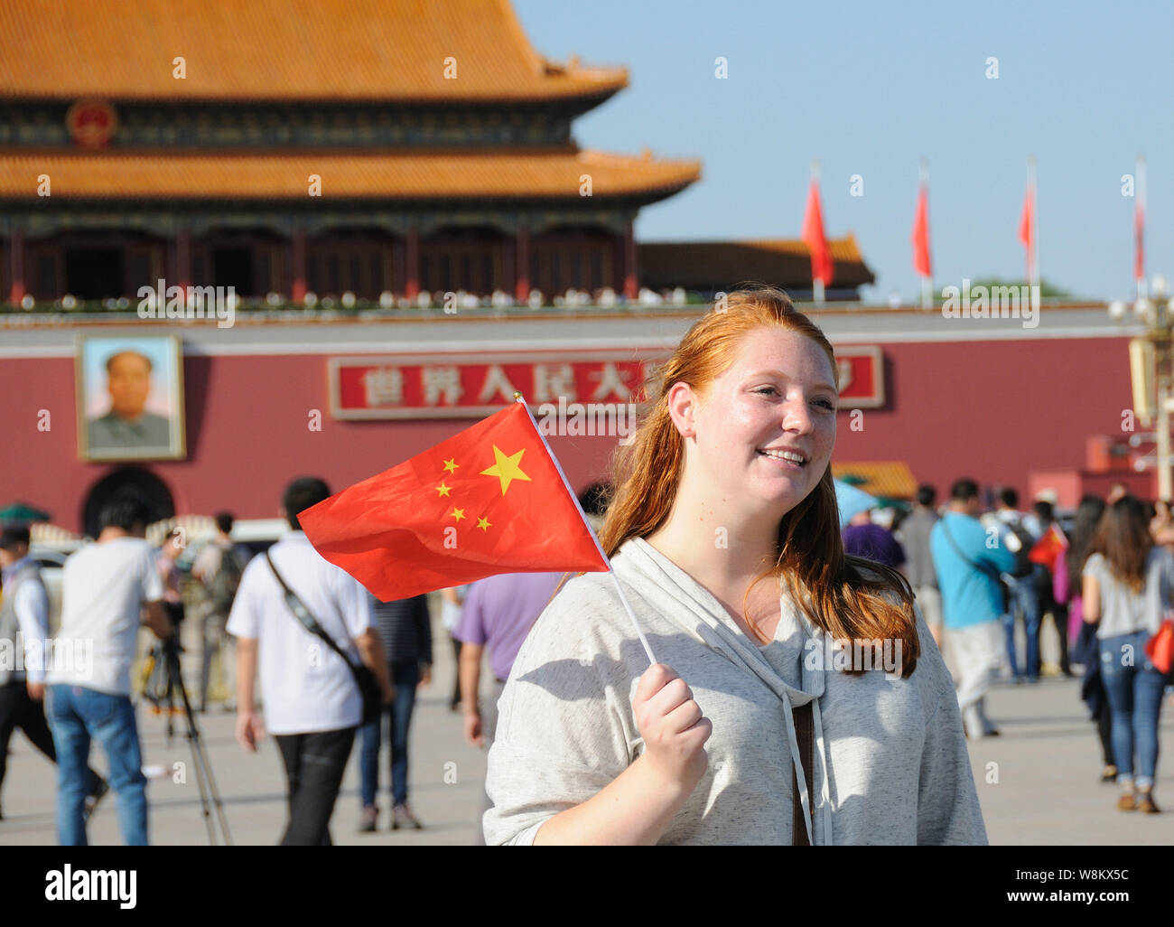 --FILE--A foreign tourist holding a Chinese national flag poses for ...