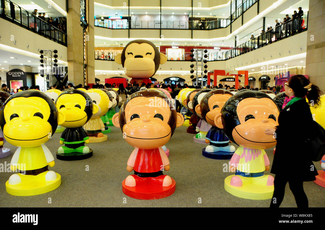 Shoppers look at models of cartoon monkey figures on display to ...