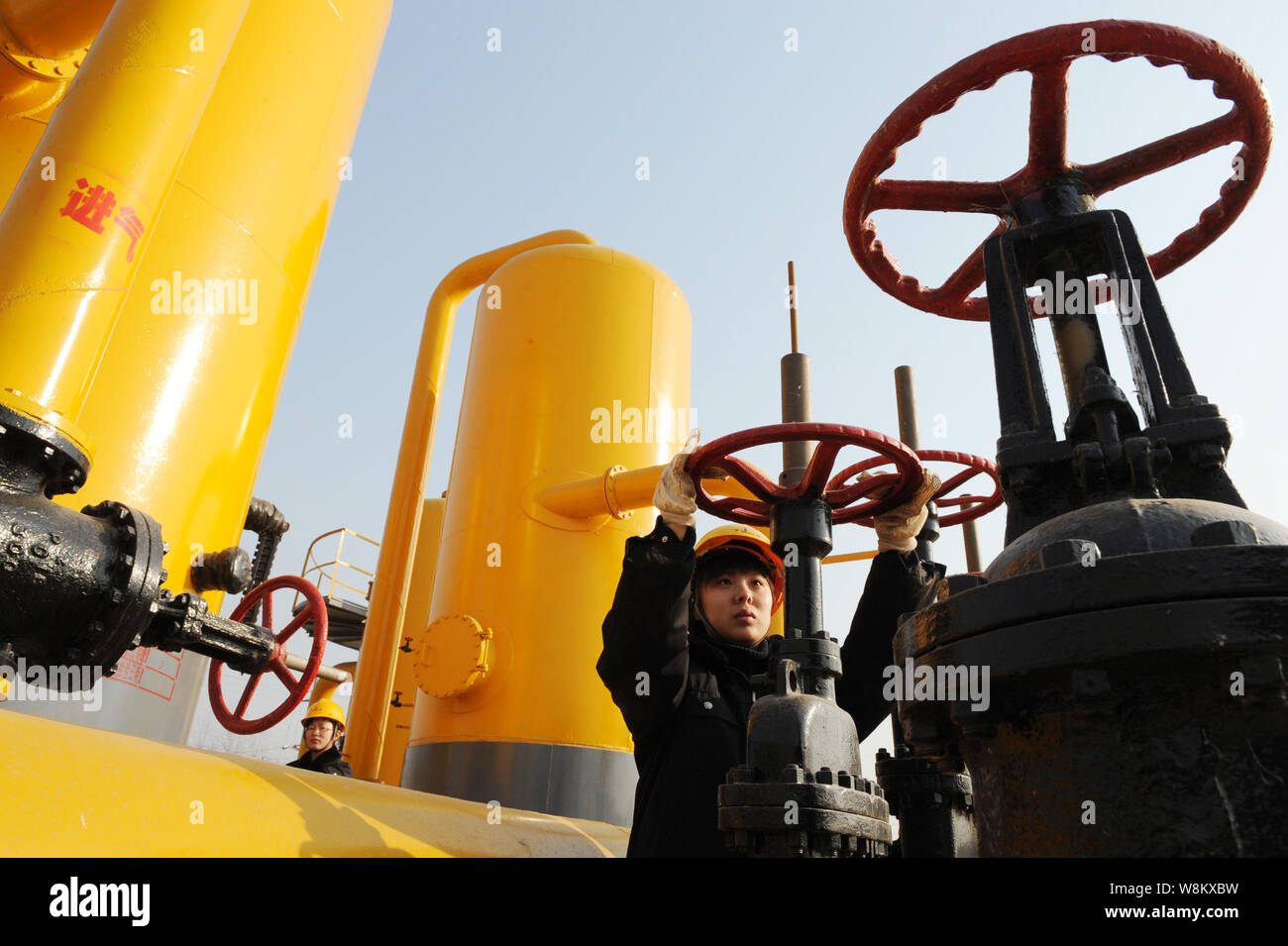 --FILE--A female Chinese worker checks crude oil production facilities ...