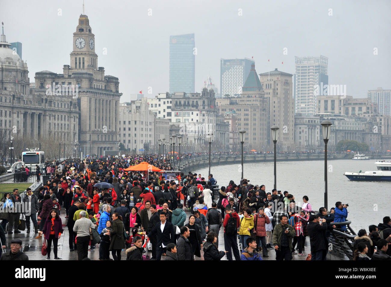 Tourists crowd the promenade on the Bund along Huangpu River to ...