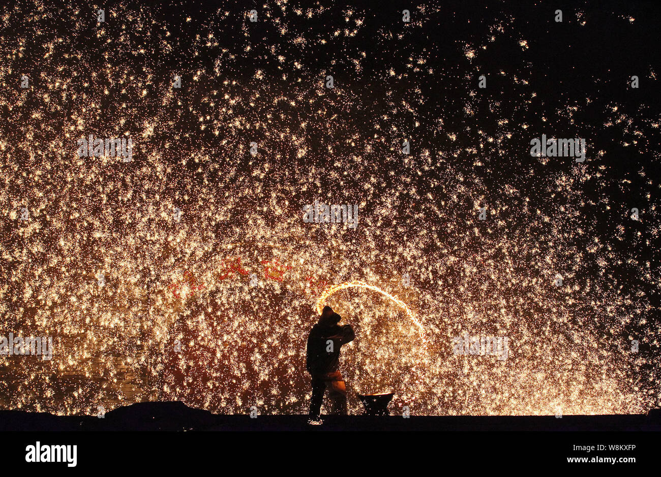 A Chinese blacksmith throws molten iron against a wall to create ...