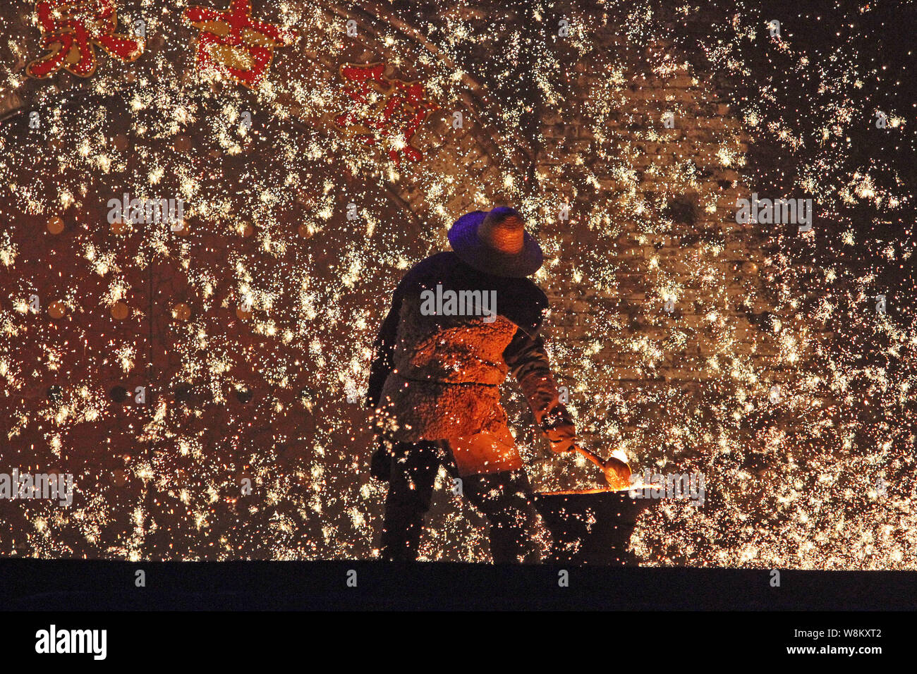 A Chinese blacksmith throws molten iron against a wall to create ...