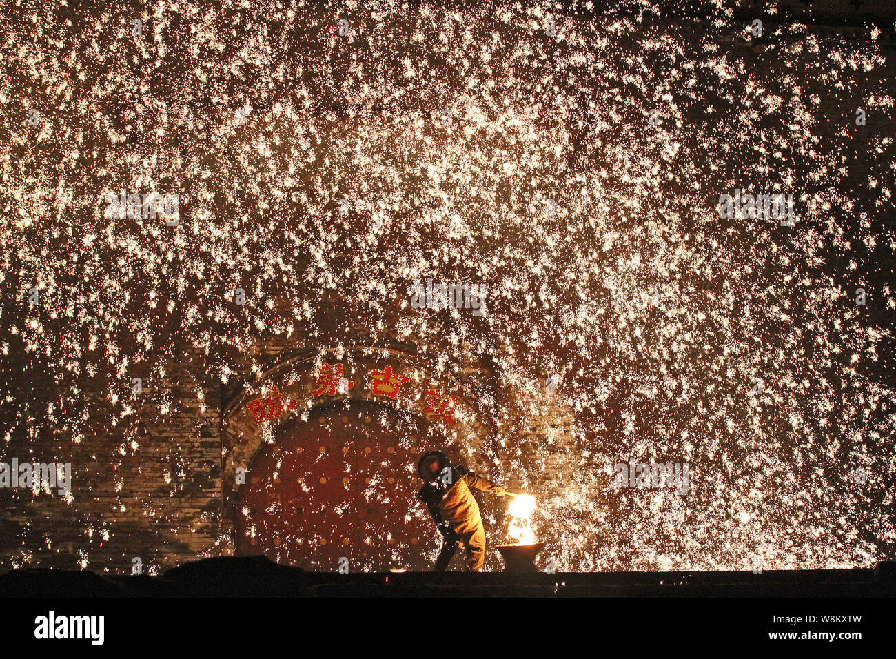 A Chinese blacksmith throws molten iron against a wall to create ...